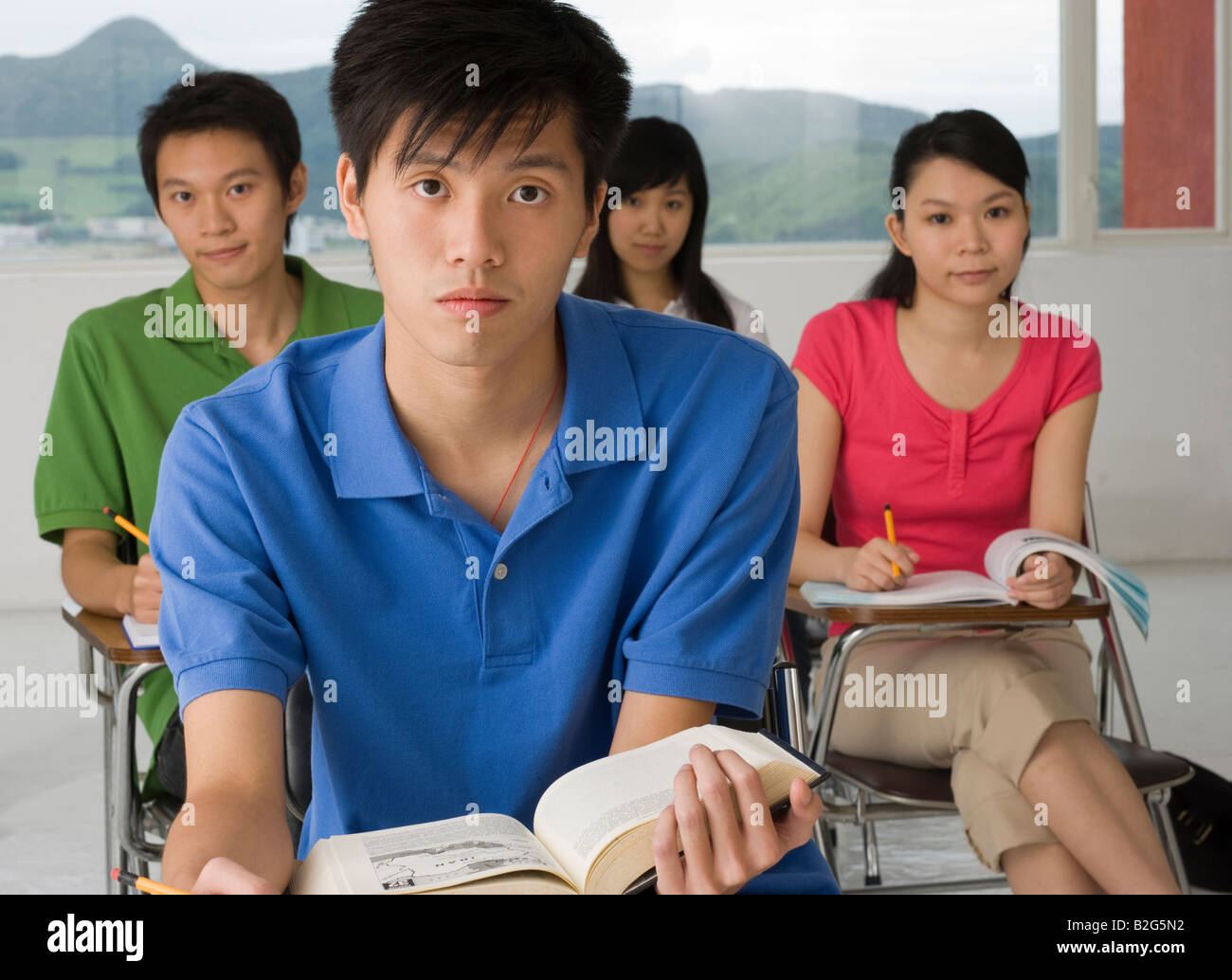 Portrait of four students in a classroom Stock Photo - Alamy