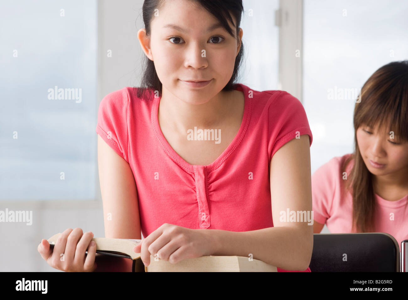 Two young women studying in a classroom Stock Photo - Alamy