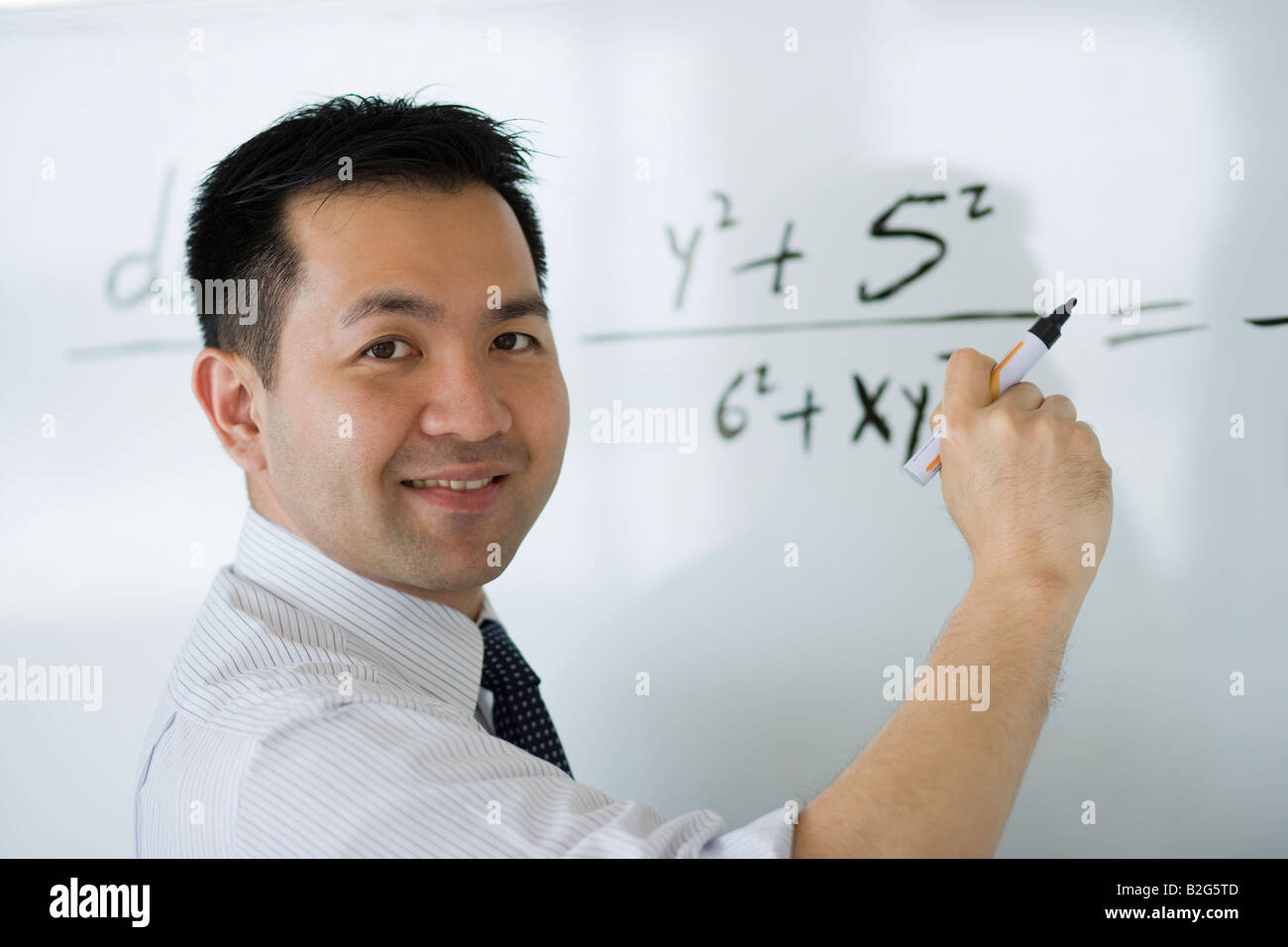 Portrait of a professor writing on a whiteboard Stock Photo - Alamy