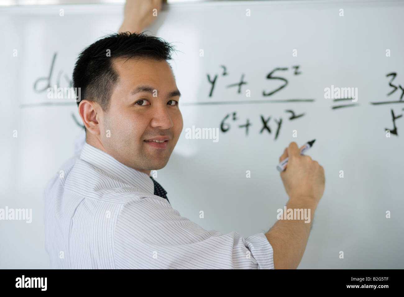 Portrait of a professor writing on a whiteboard Stock Photo - Alamy