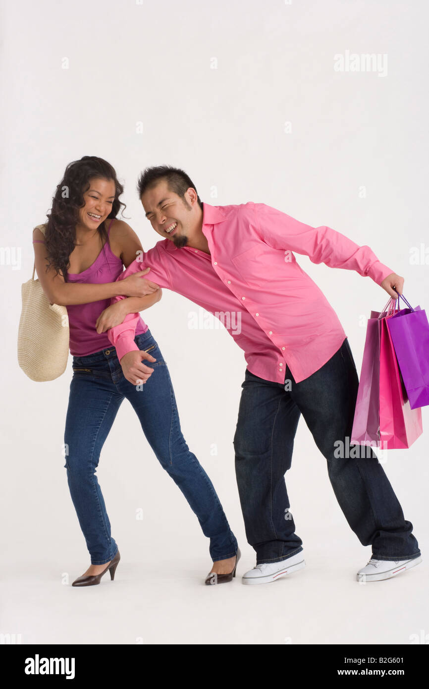 Young woman pulling a young man's hand and smiling Stock Photo - Alamy
