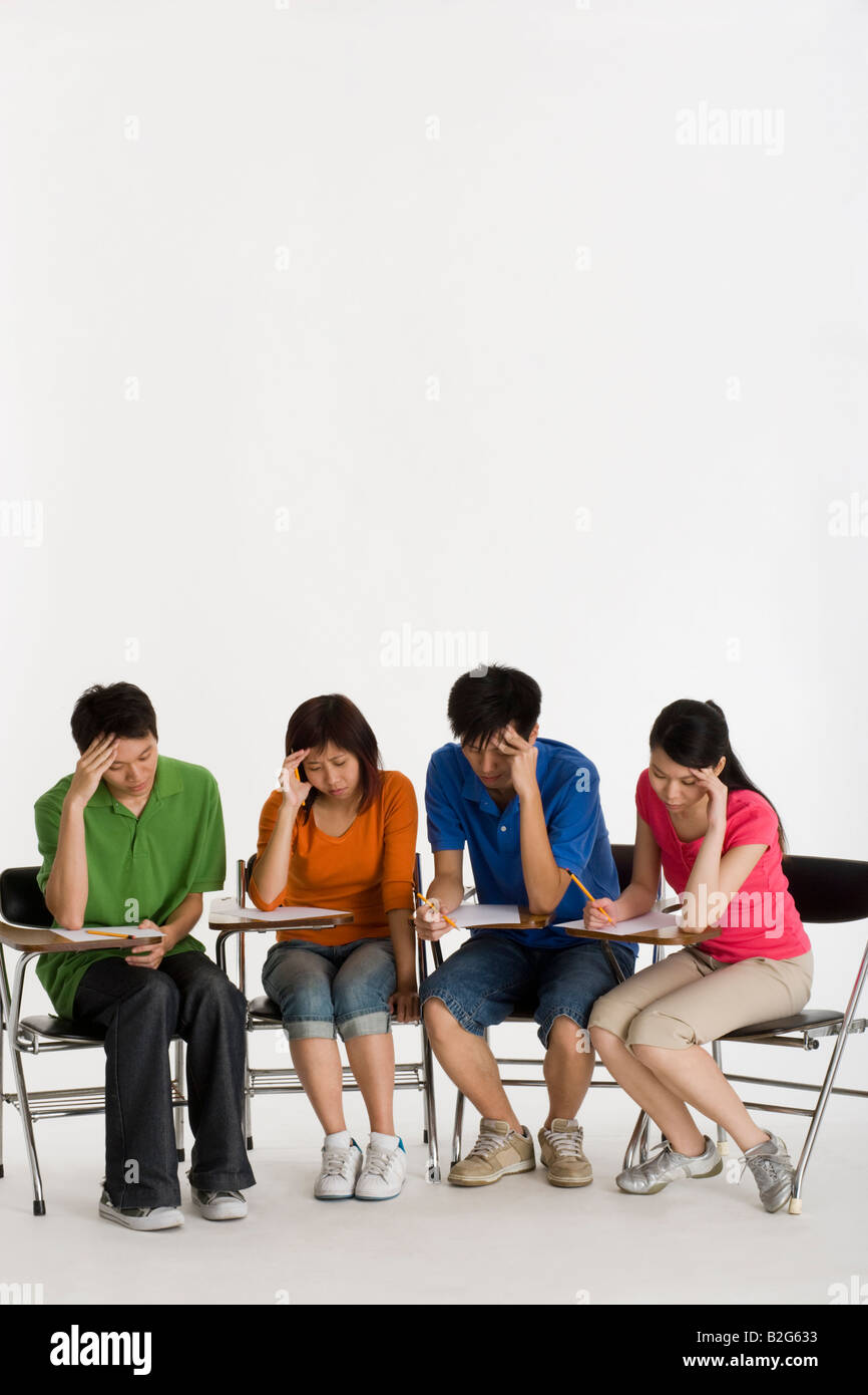 Four university students sitting on chairs Stock Photo - Alamy