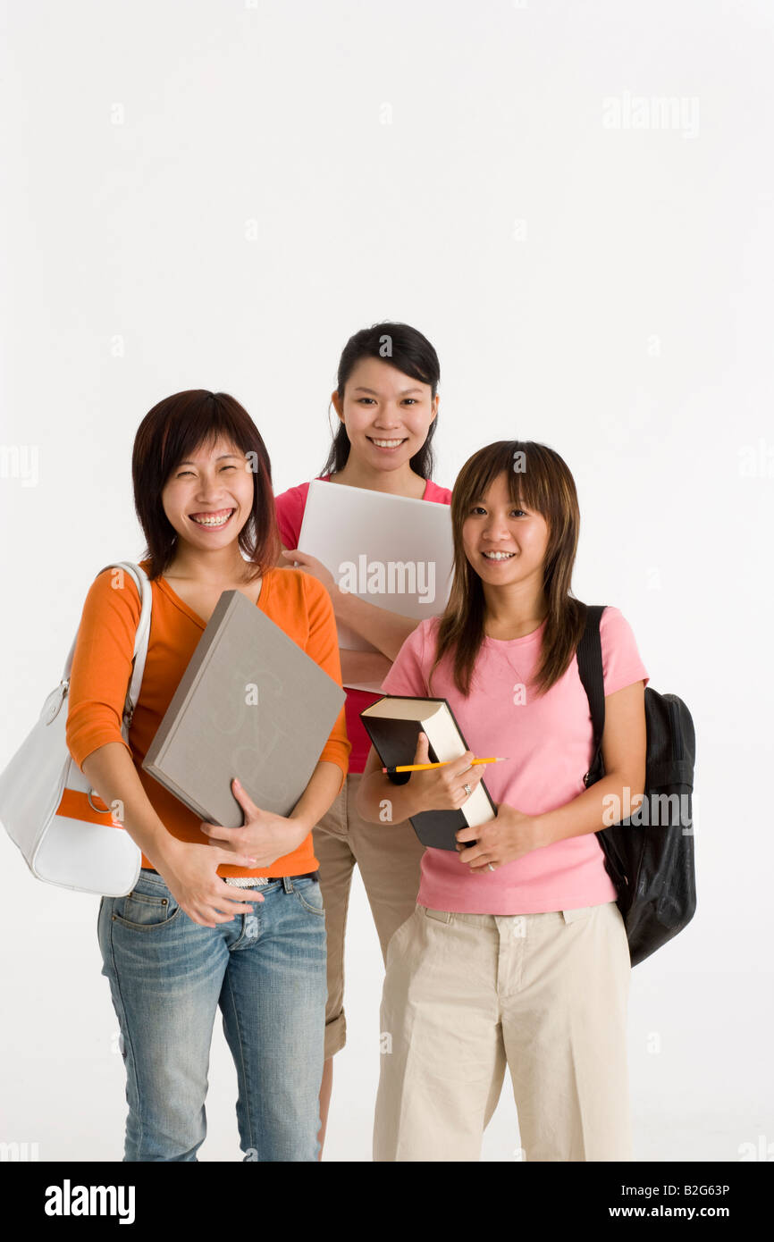 Portrait of three female university students standing and smiling ...