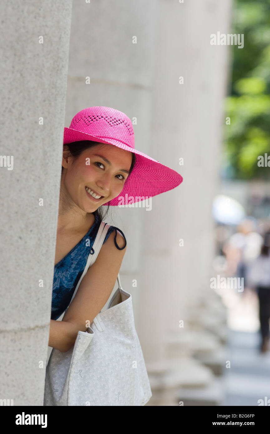 Portrait of a young woman hiding behind a column and smiling Stock ...
