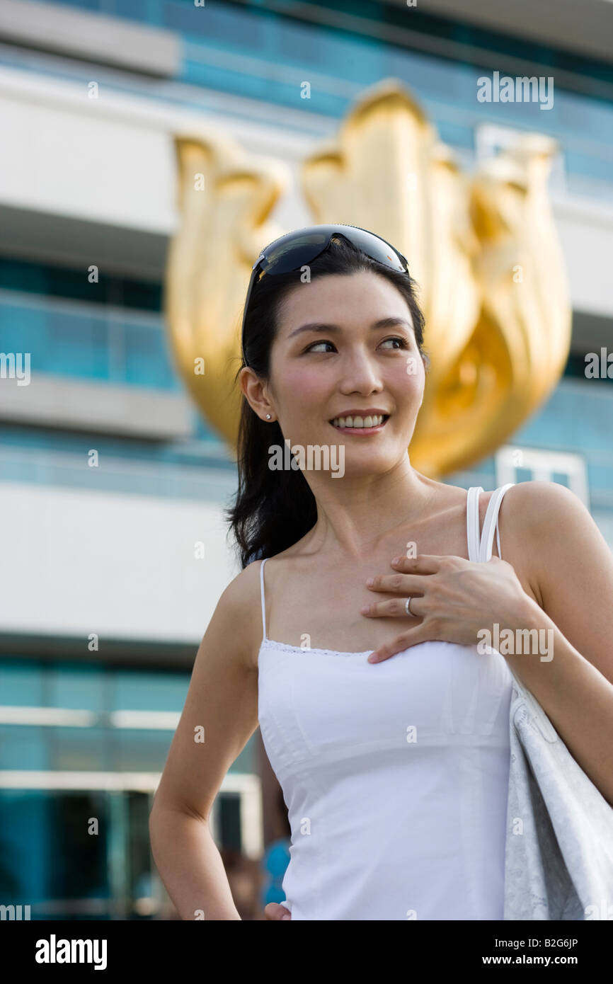 Young woman carrying a hand bag and smiling Stock Photo - Alamy