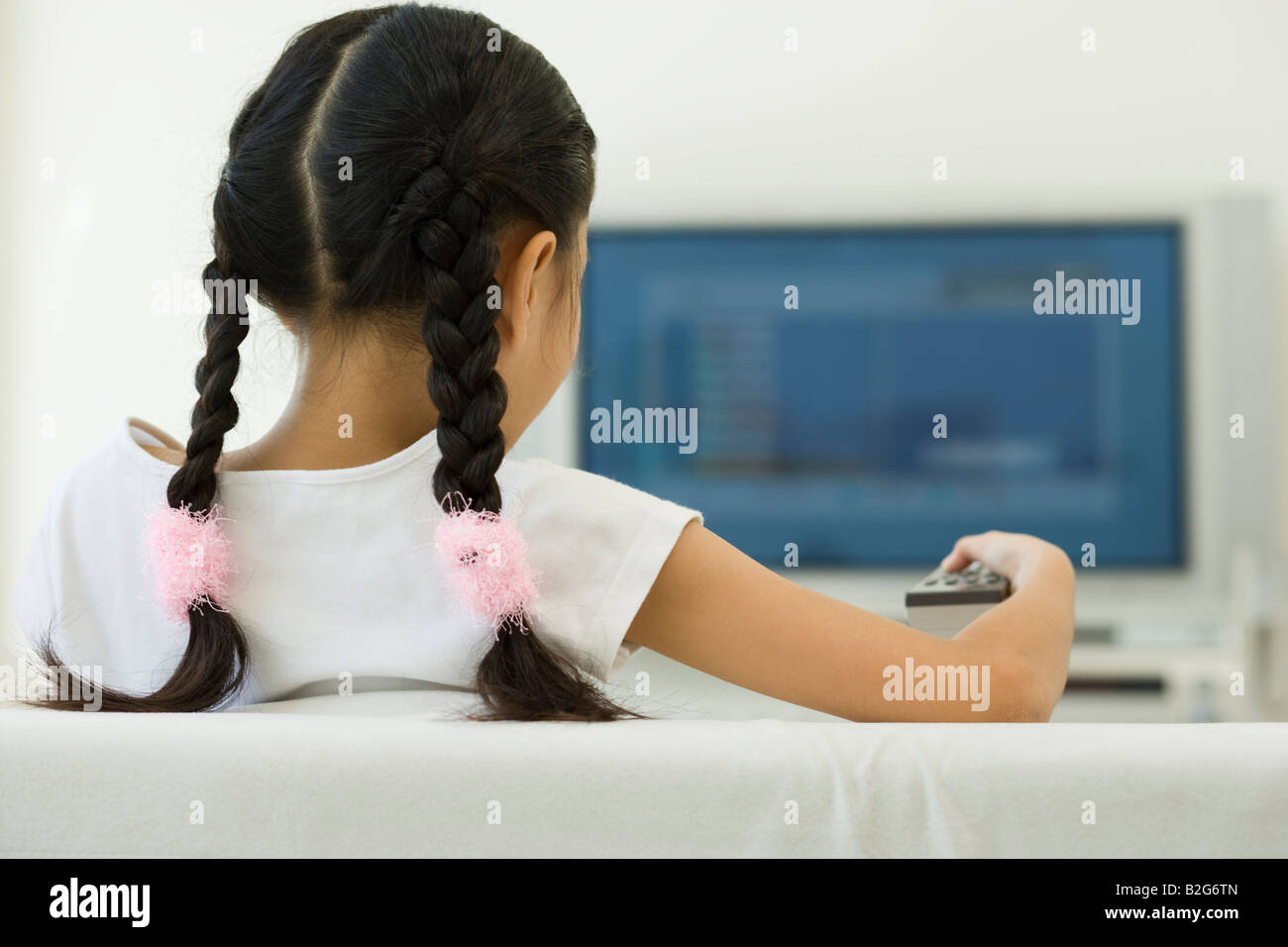 Rear view of a girl watching television Stock Photo - Alamy