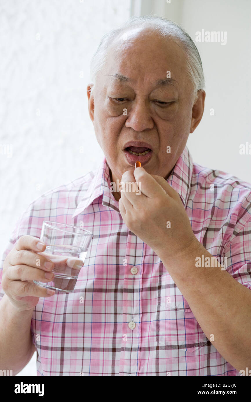 Close-up of a senior man taking a capsule Stock Photo - Alamy
