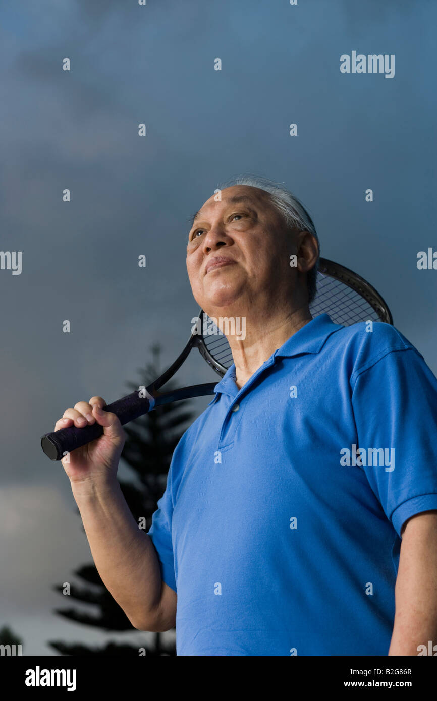 Low angle view of a senior man holding a tennis racket Stock Photo - Alamy