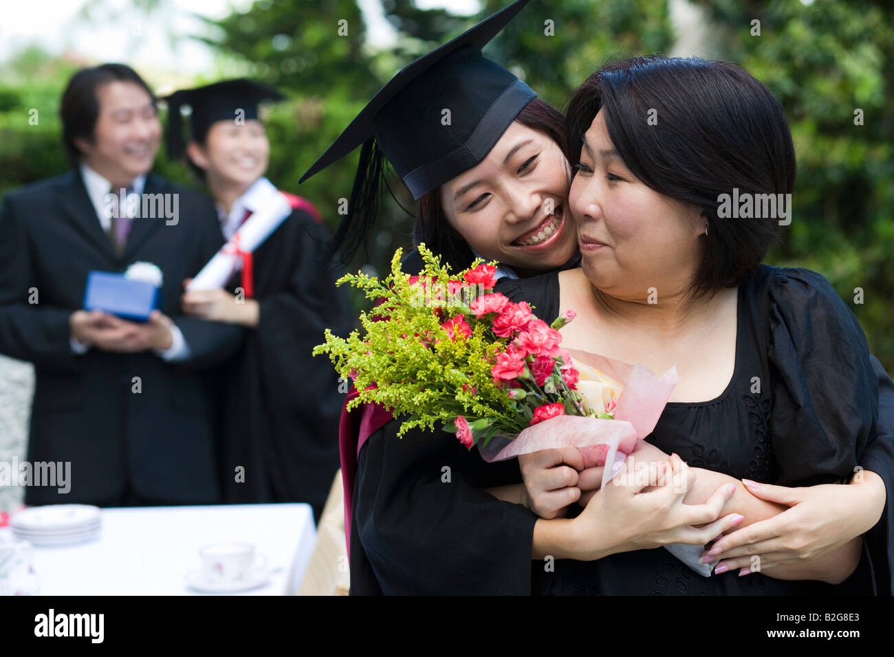 Close-up of a mid adult female graduate hugging her mother Stock Photo ...