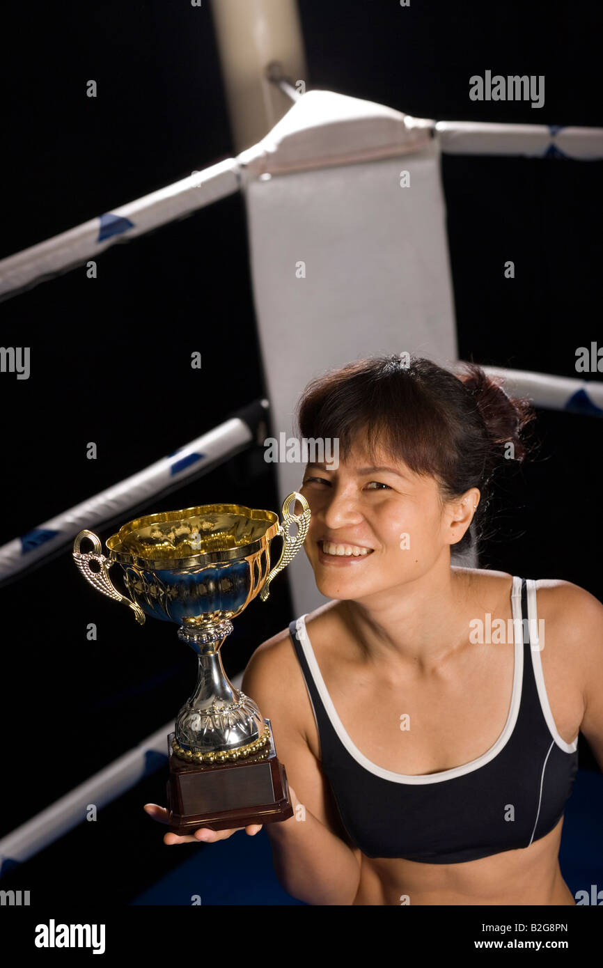 Young woman holding a trophy and smiling in a boxing ring Stock Photo ...