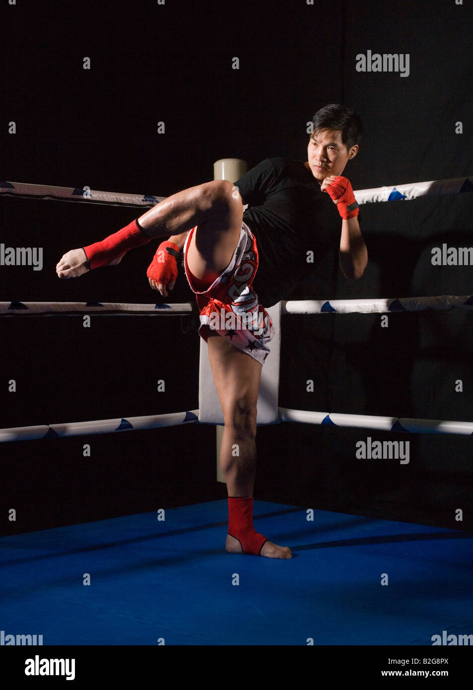 Mid adult man practicing kickboxing in a boxing ring Stock Photo - Alamy