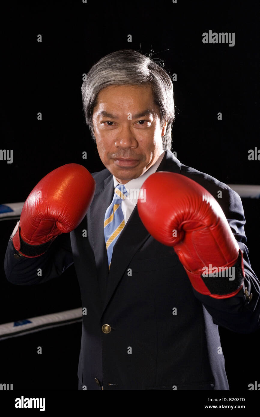 Businessman wearing boxing gloves in a boxing ring Stock Photo - Alamy