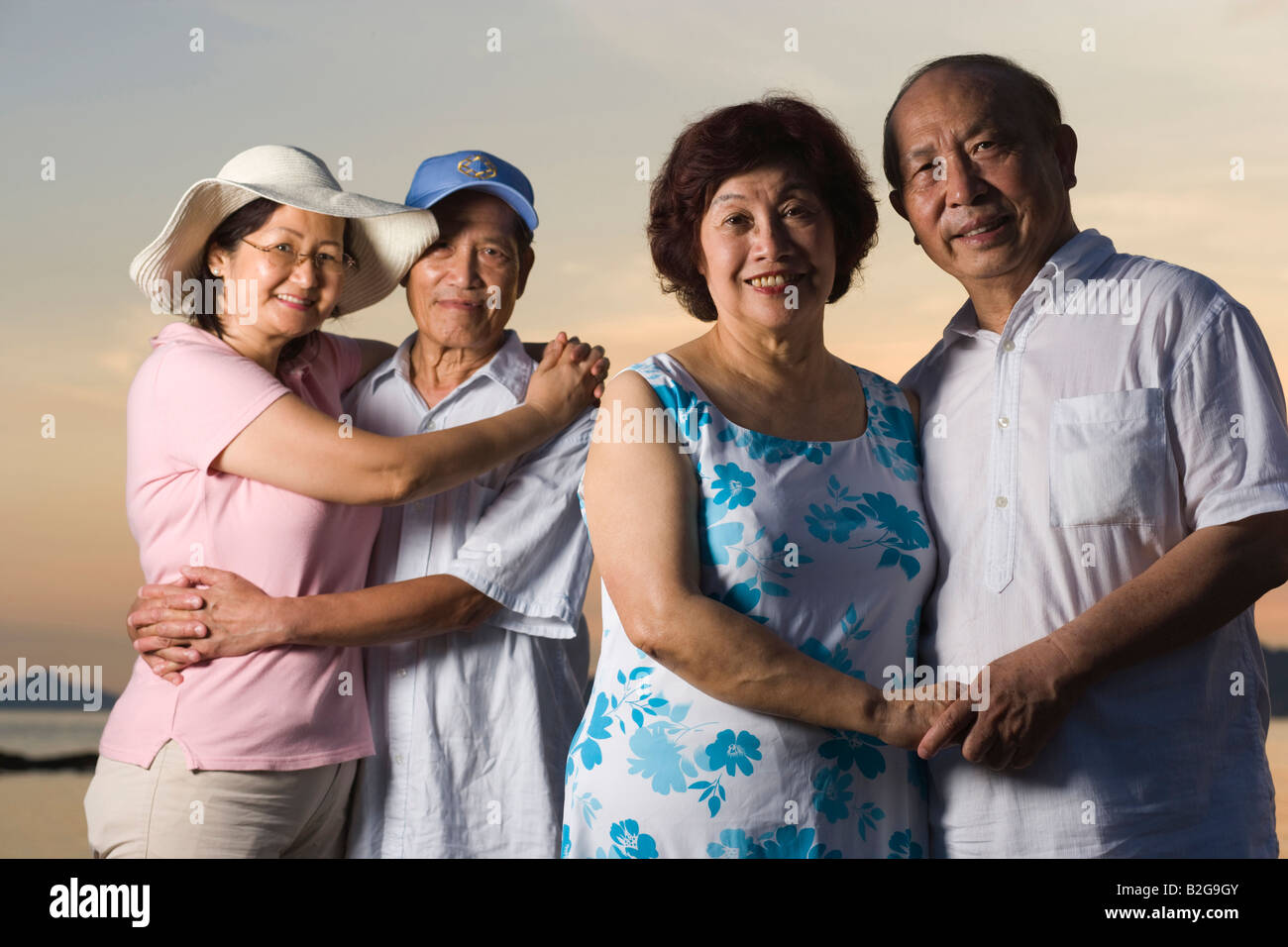 Two couples standing together and smiling Stock Photo - Alamy