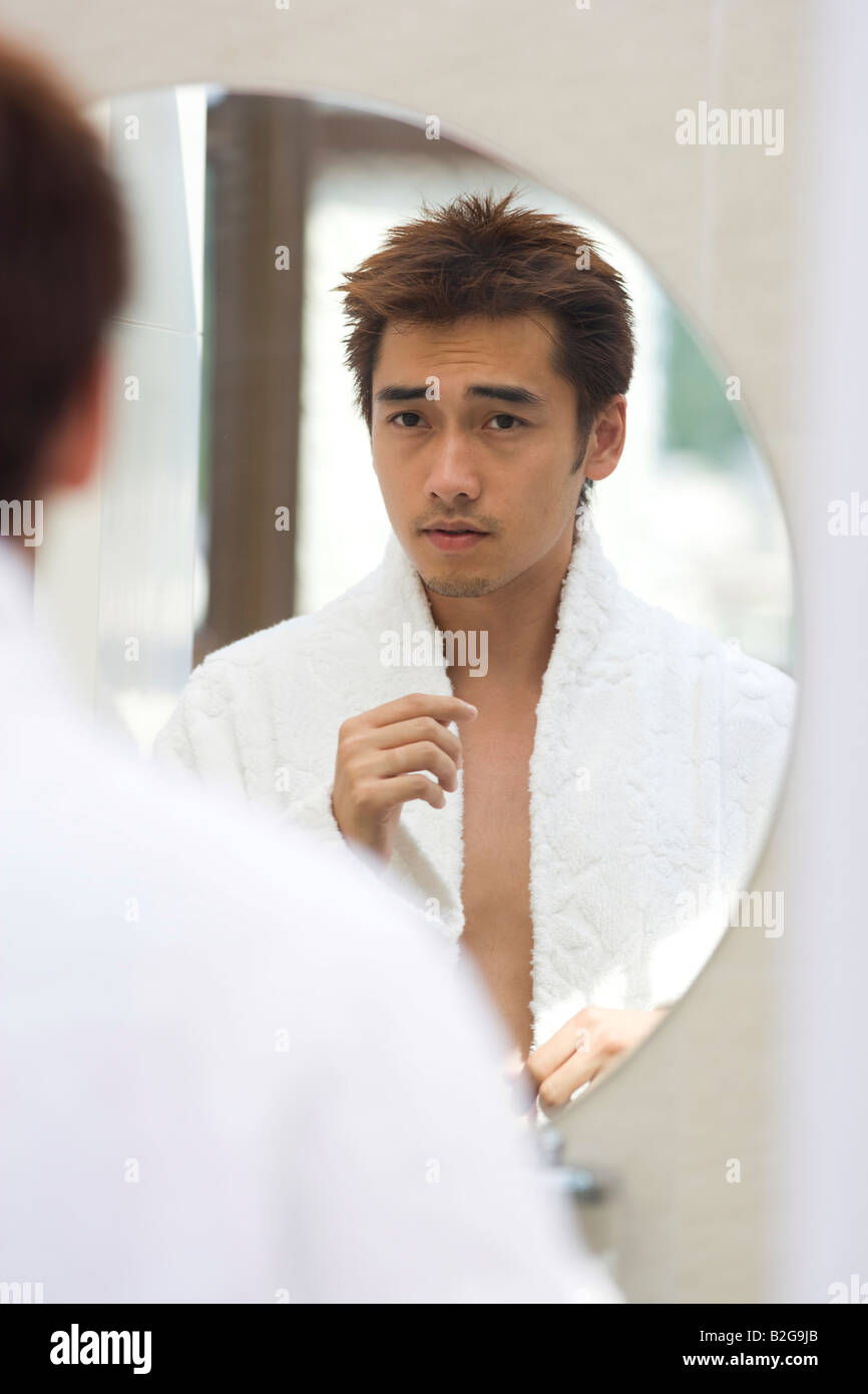 Young man standing in front of a mirror Stock Photo - Alamy