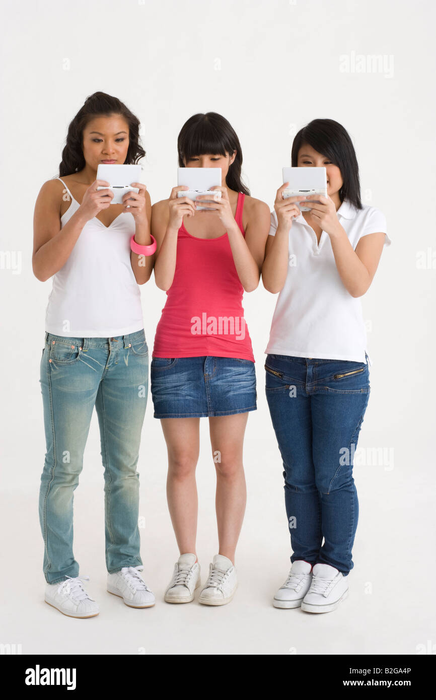 Three young women using personal data assistants Stock Photo - Alamy