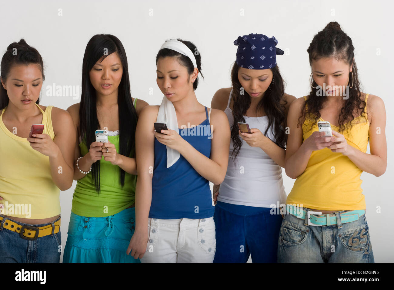 Five young women text messaging Stock Photo - Alamy