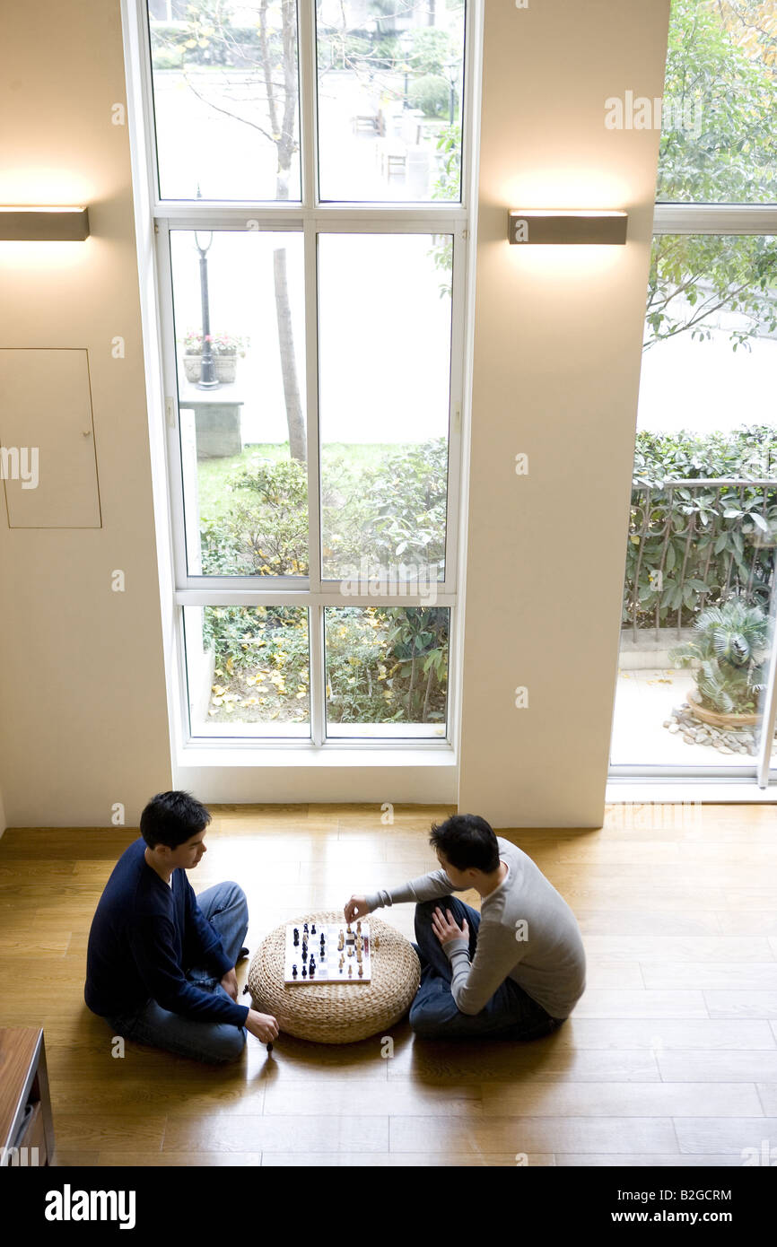 Elevated view of friends playing chess Stock Photo - Alamy