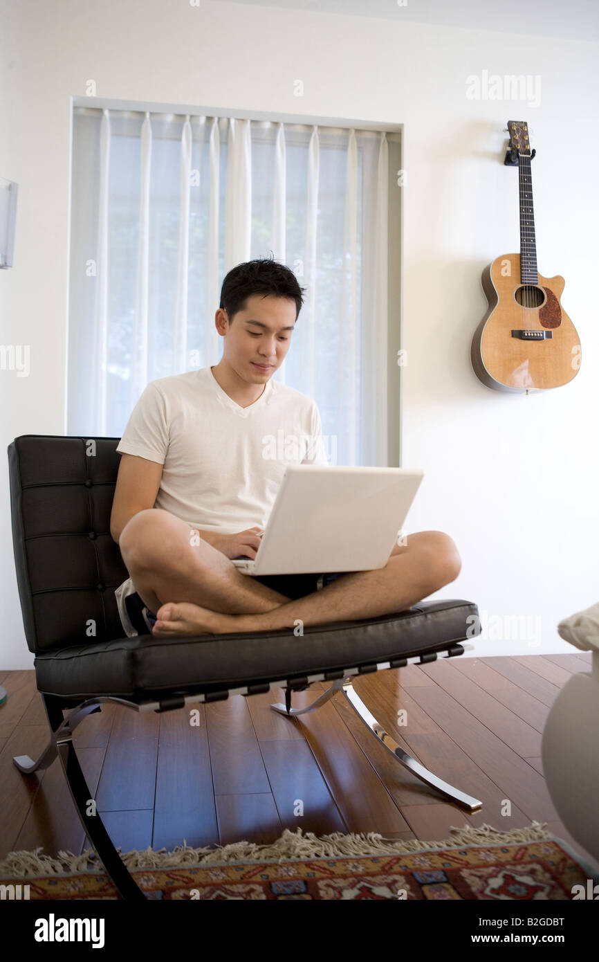 Young man using a laptop Stock Photo - Alamy