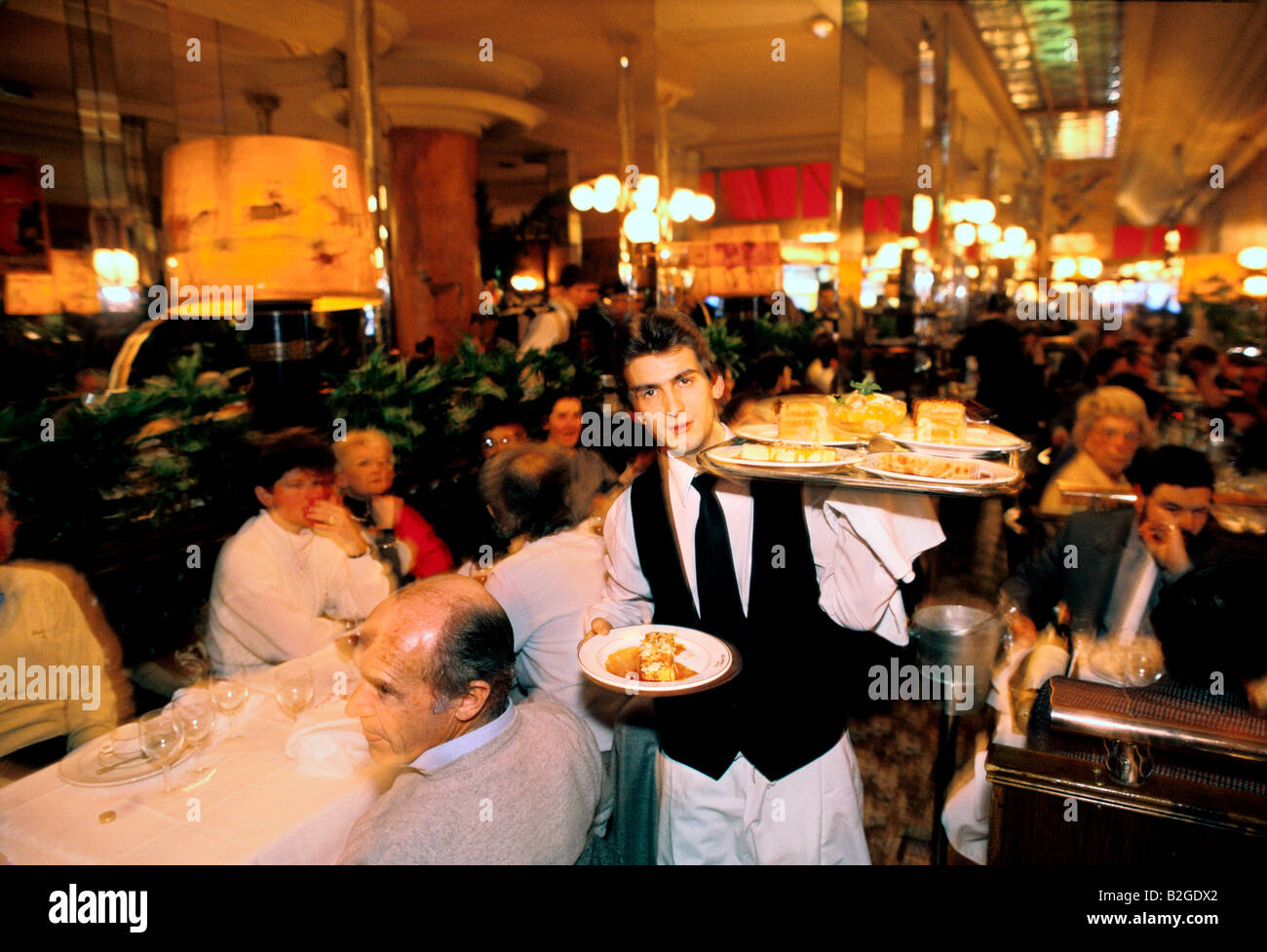 WAITER CARRYING A FULL TRAY OF DESSERTS IN CAFE Stock Photo - Alamy