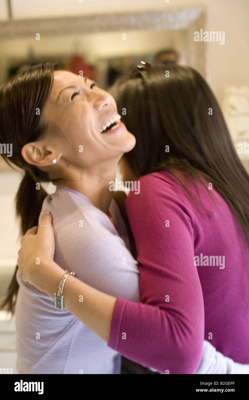 Side view of girlfriends hugging each other Stock Photo - Alamy