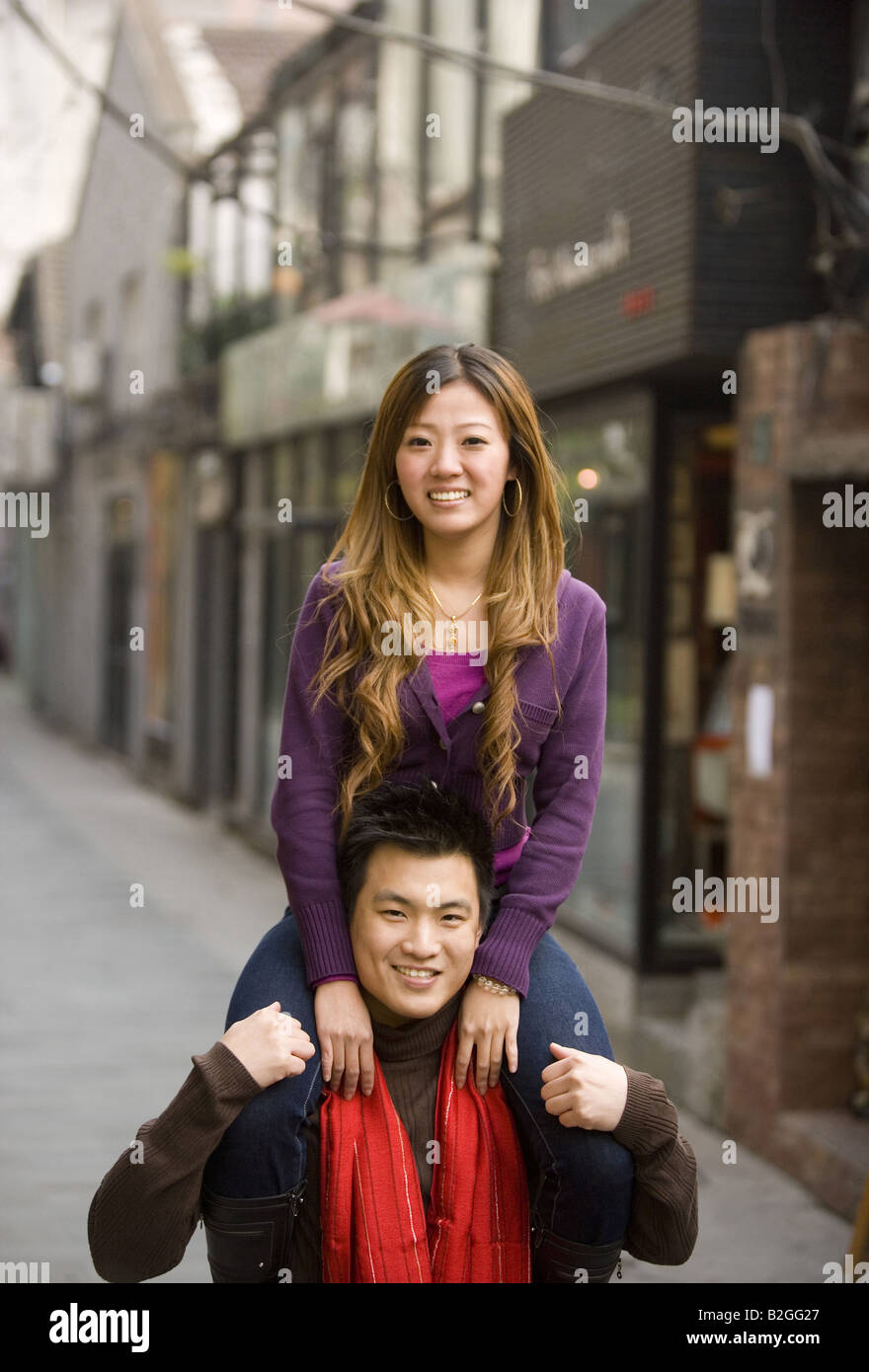 Portrait of a young woman on a man's shoulders Stock Photo - Alamy