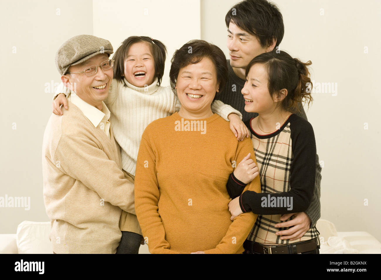 Portrait of a family sitting side by side Stock Photo - Alamy