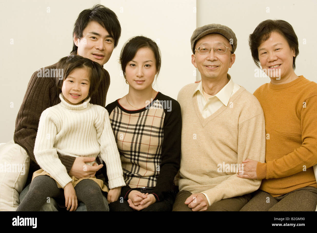 Portrait of a family sitting side by side Stock Photo - Alamy