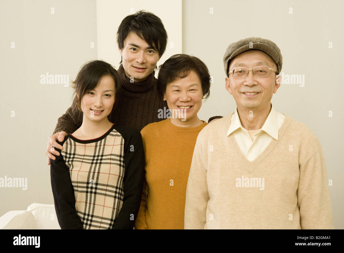 Portrait of a young couple standing with their parents and smiling ...