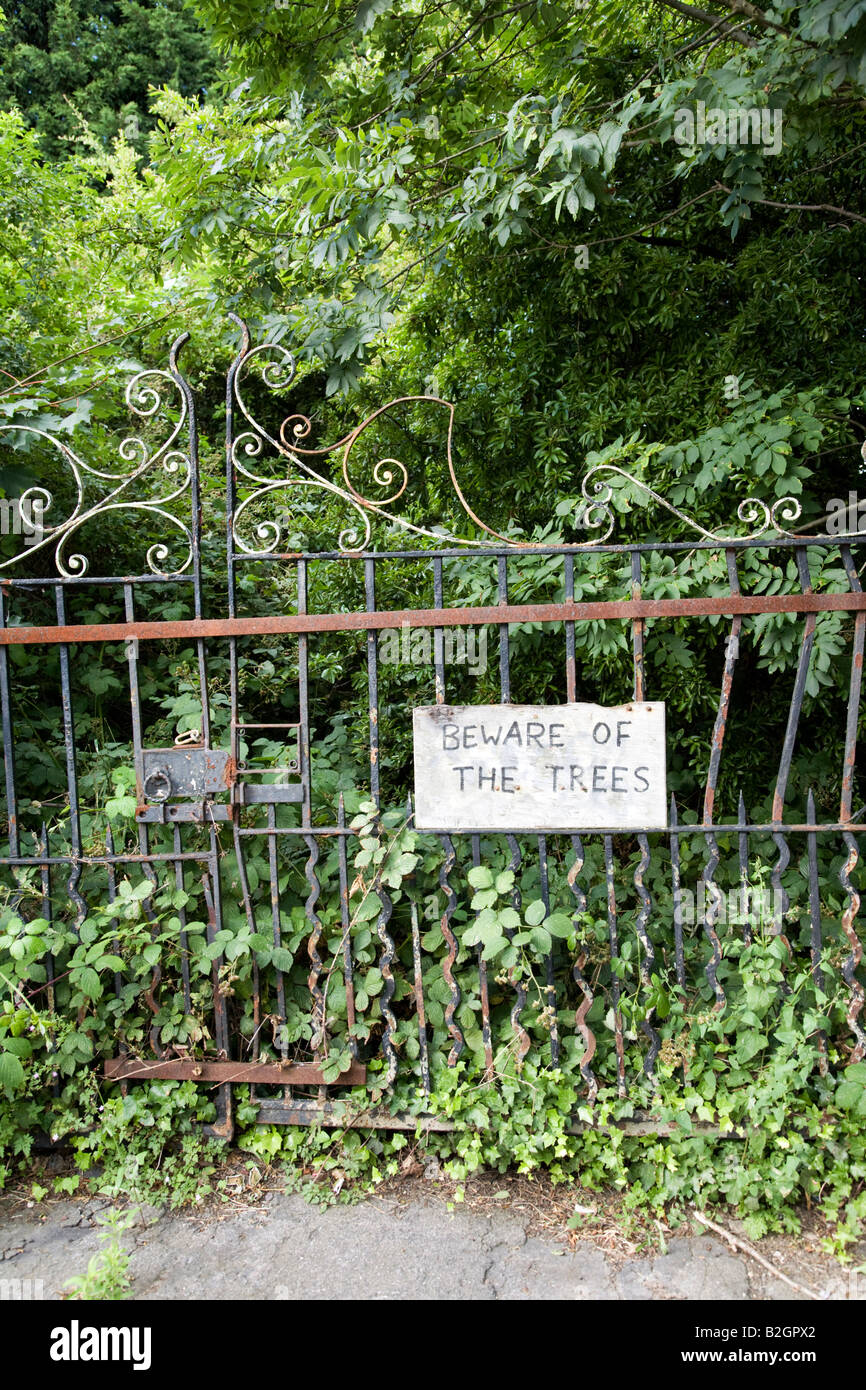 A sign 'Beware of the trees' outside a small overgrown area Stock Photo ...