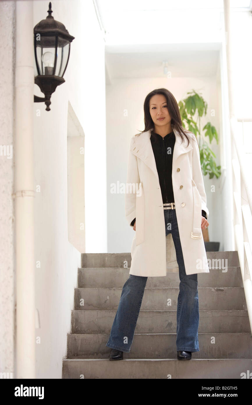 Portrait of a young woman standing on steps Stock Photo - Alamy