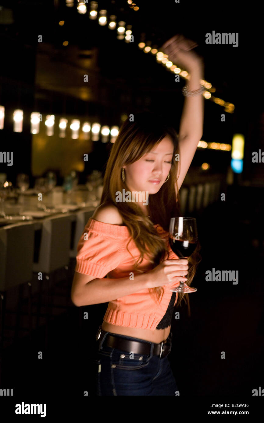 Young woman dancing in a bar and holding a glass of red wine Stock ...