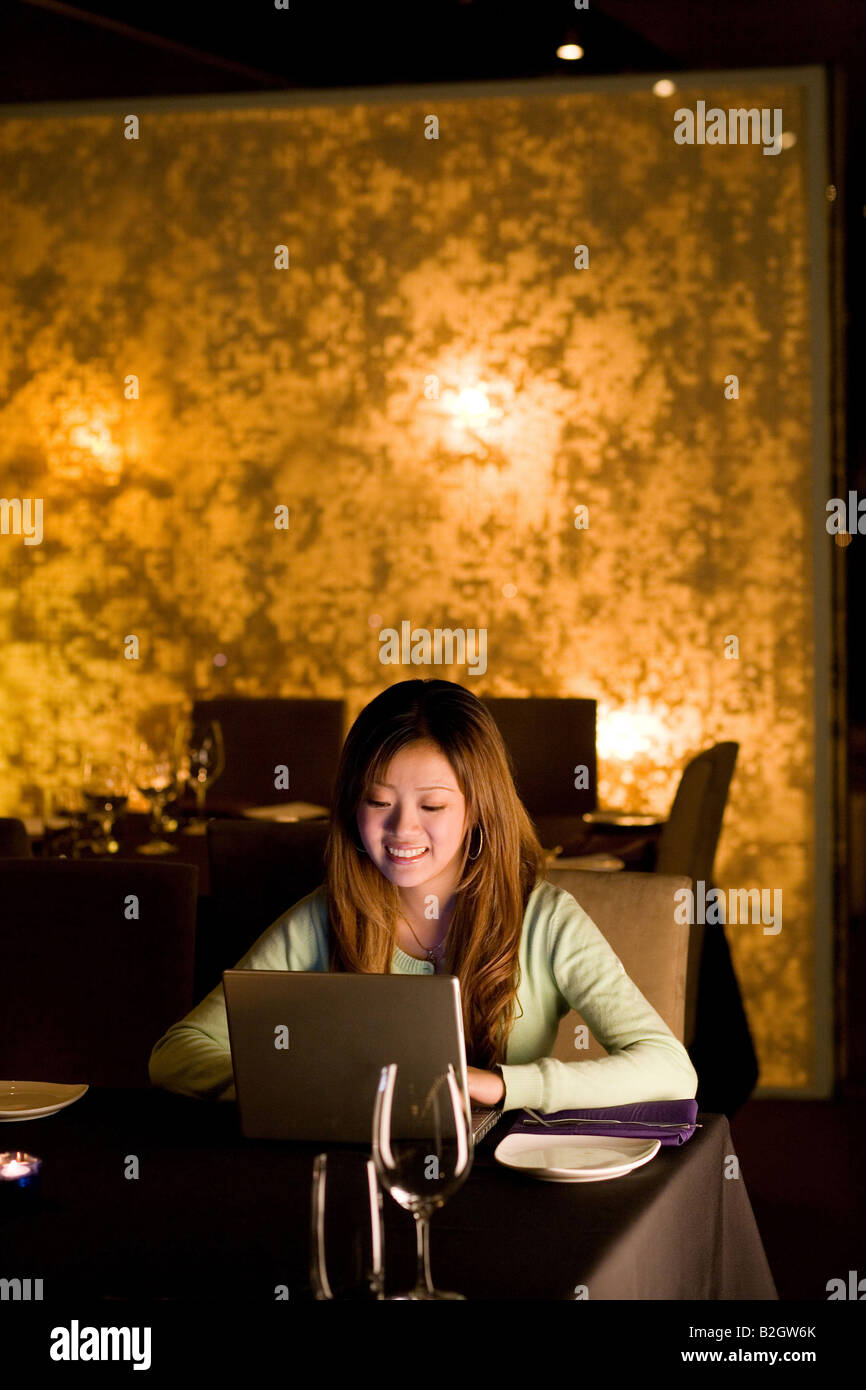 Businesswoman using a laptop in a bar Stock Photo - Alamy