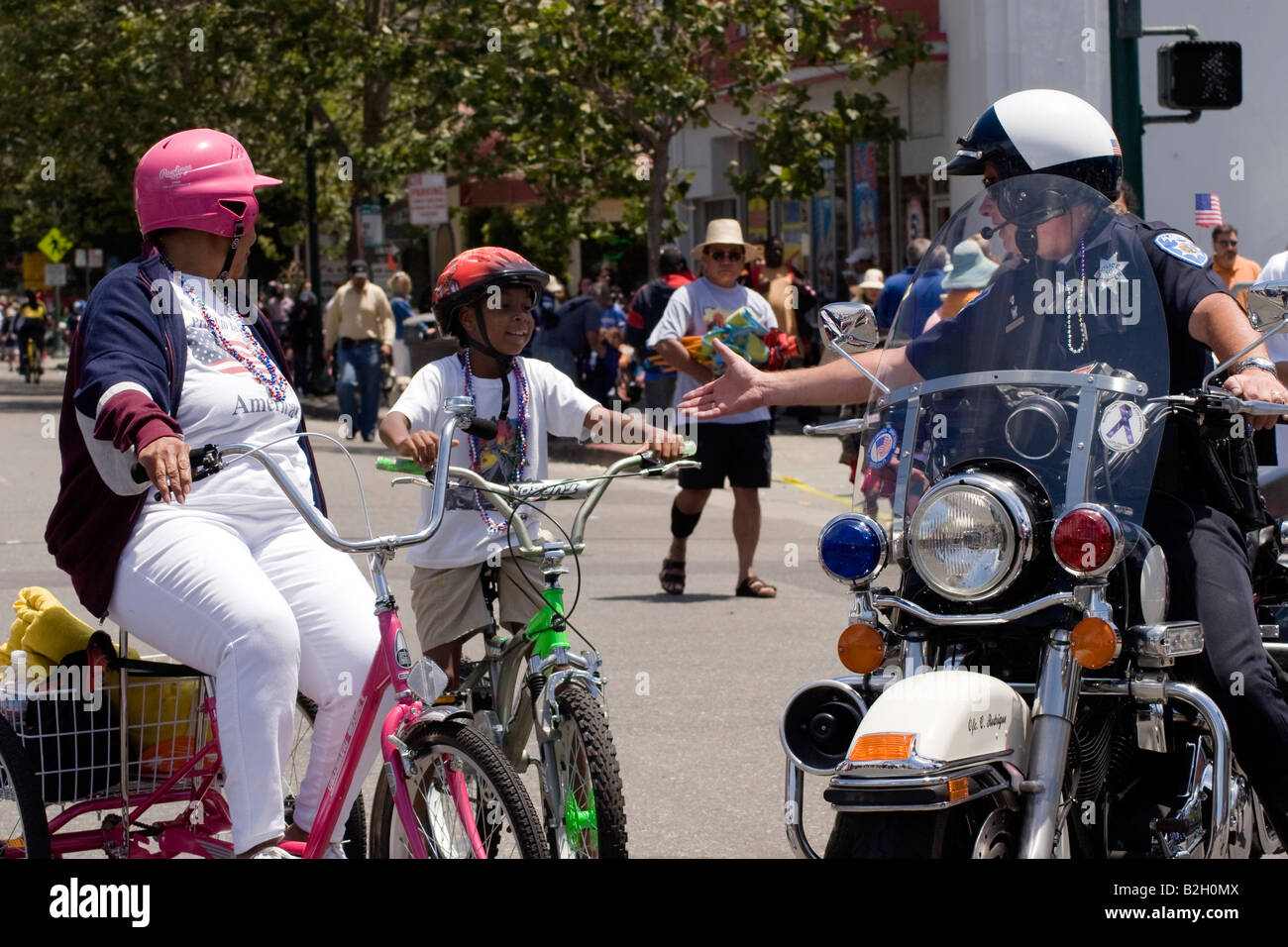 Police officer reaching out to child at July 4 Independence Day Parade ...