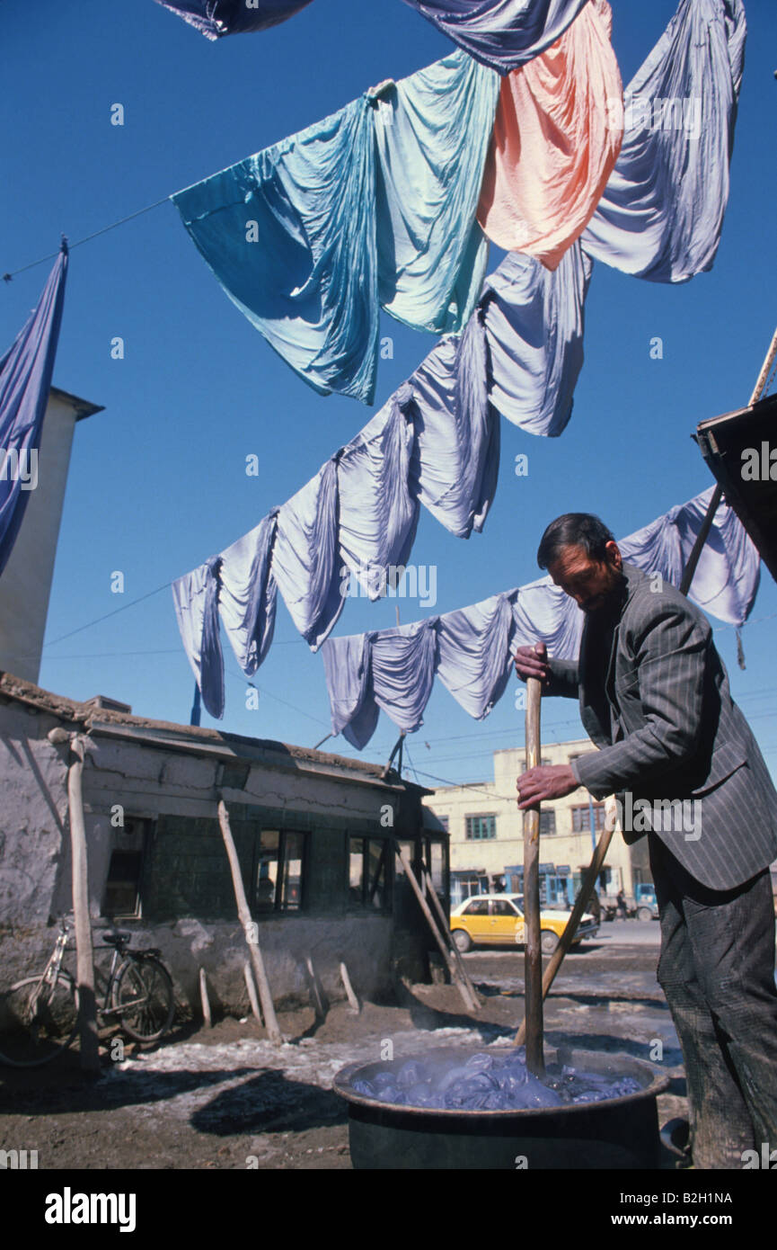 An Afghan man stirs boiling dye for traditional womens full body ...