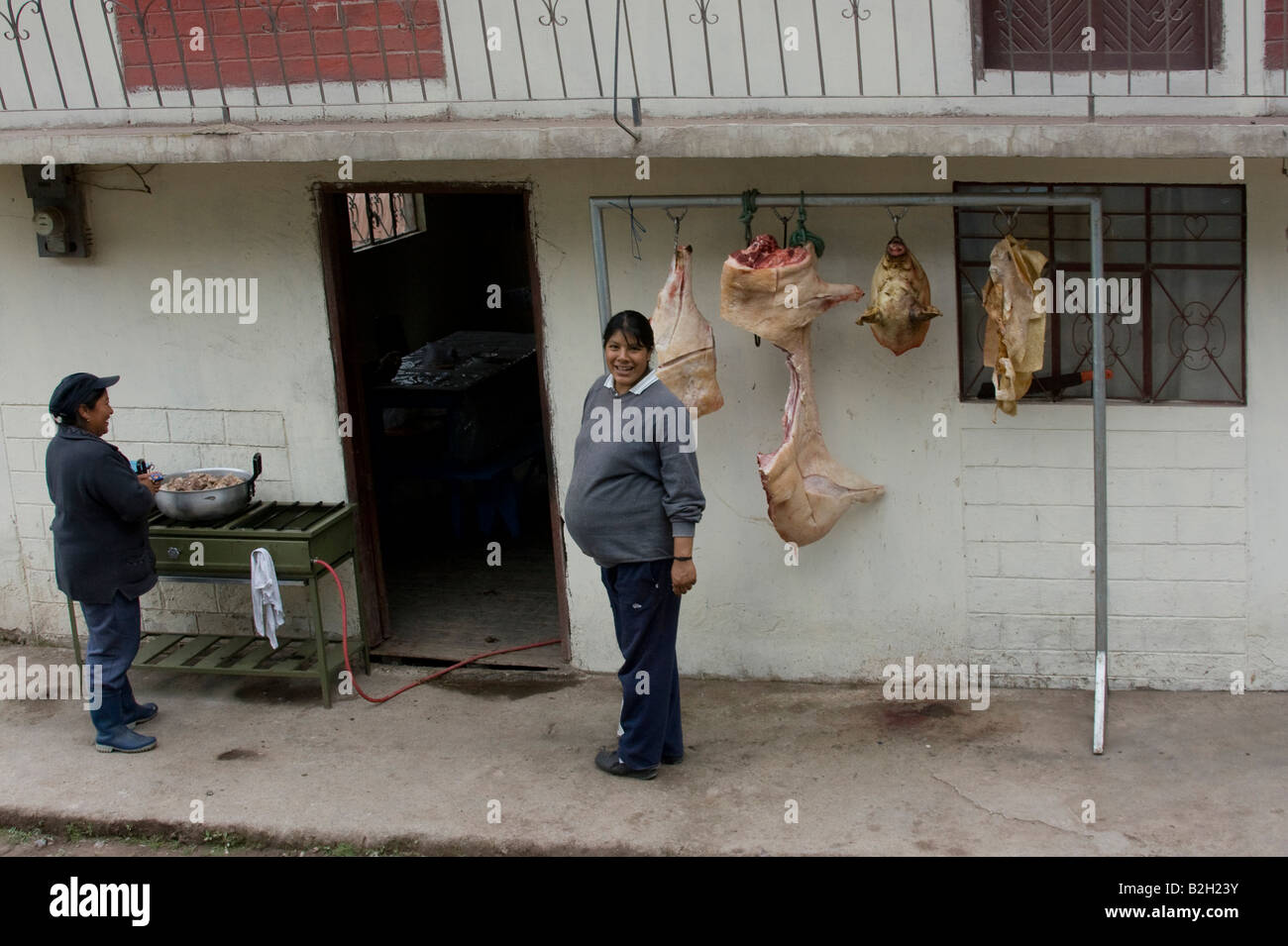 Pregnant Woman outside butcher shop. exposed meat hanging. Ecuador ...