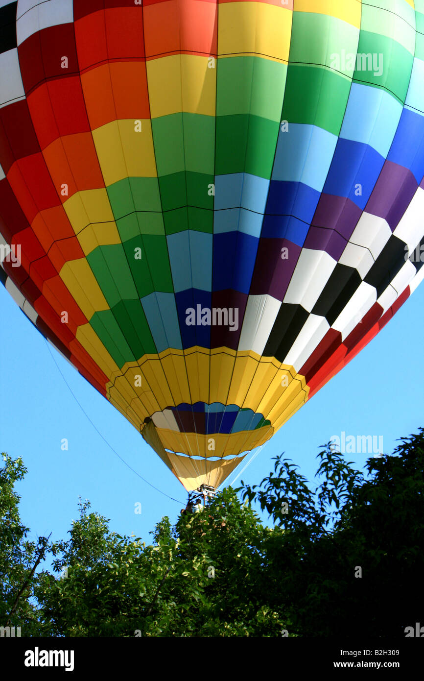 A hot air balloon floating at the treetops Stock Photo - Alamy