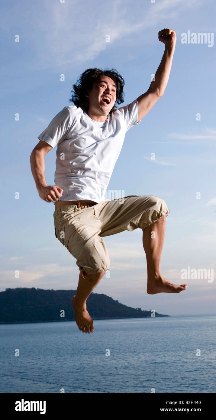 Low angle view of a young man jumping, Phuket, Thailand Stock Photo - Alamy