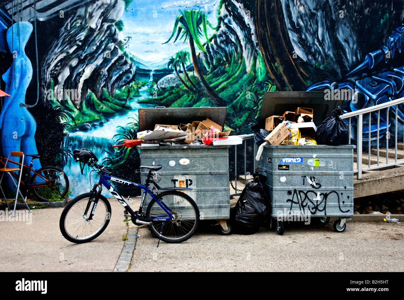 Bicycle sitting in front of over-flowing dumpsters with beautiful ...