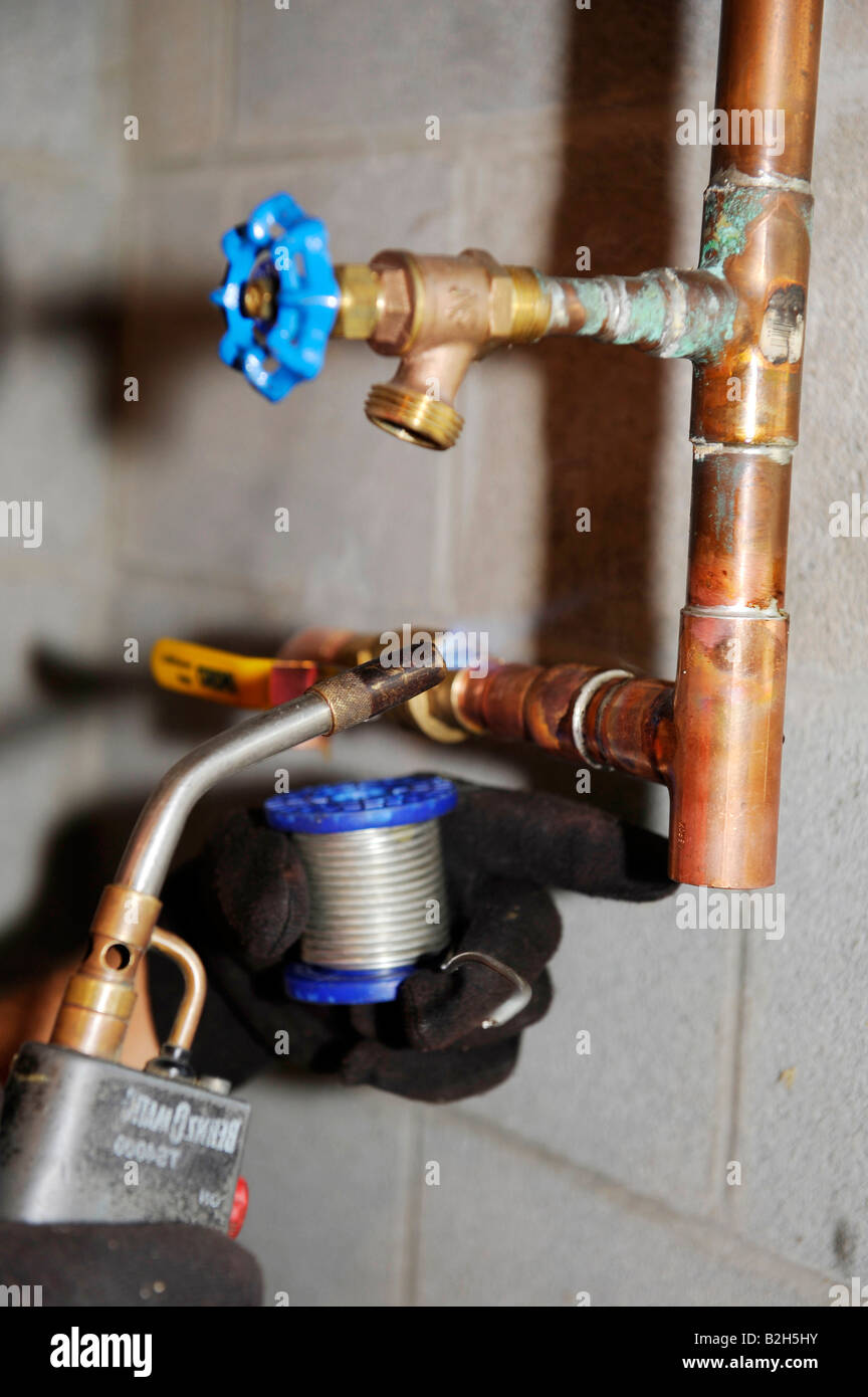 Plumber installing copper water piping for new residential home Stock ...