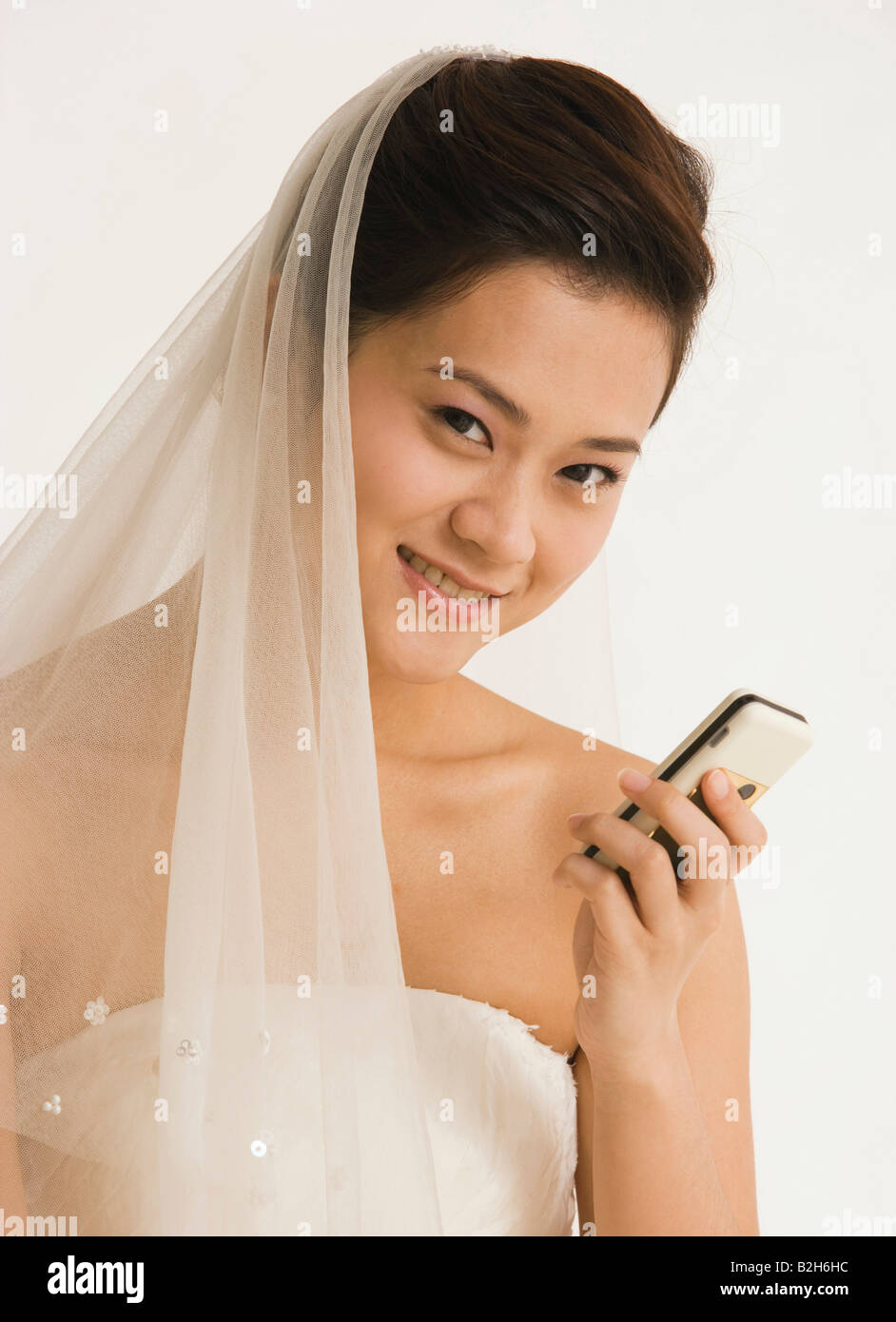 Portrait of a bride holding a mobile phone and smiling Stock Photo - Alamy