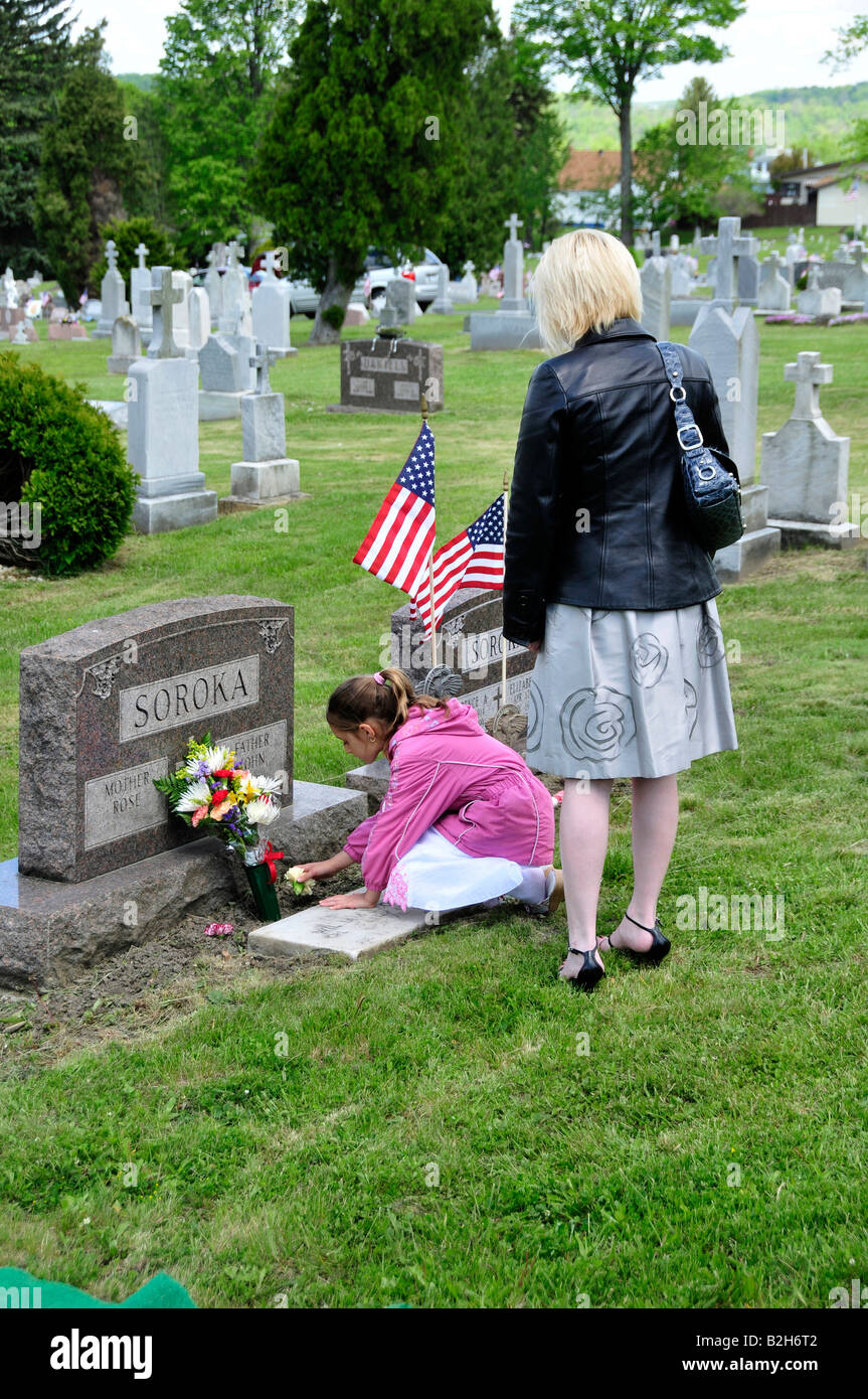 Family places flowers at gravesite Stock Photo - Alamy