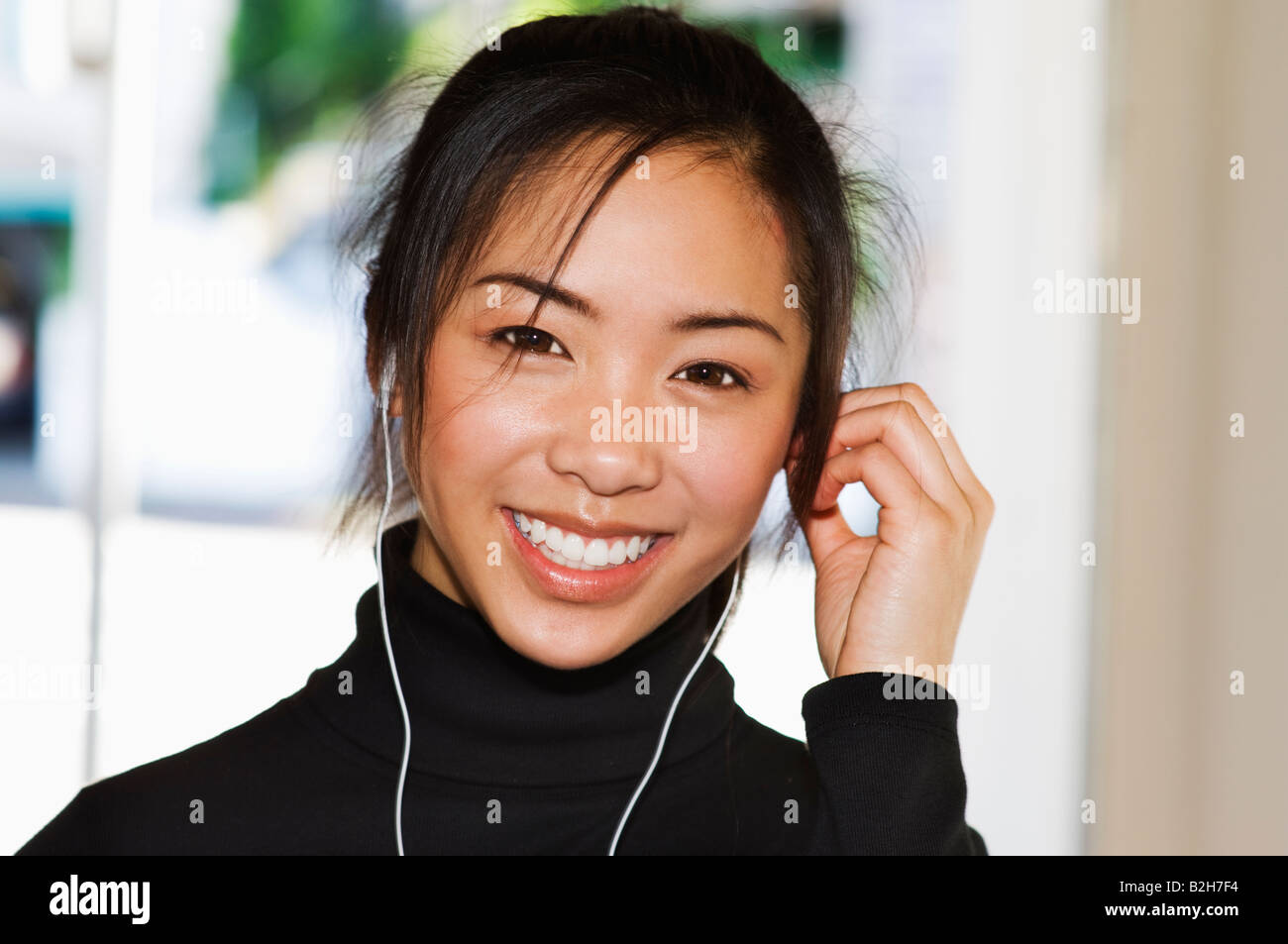 Asian girl listening to music on an ipod itouch Stock Photo - Alamy