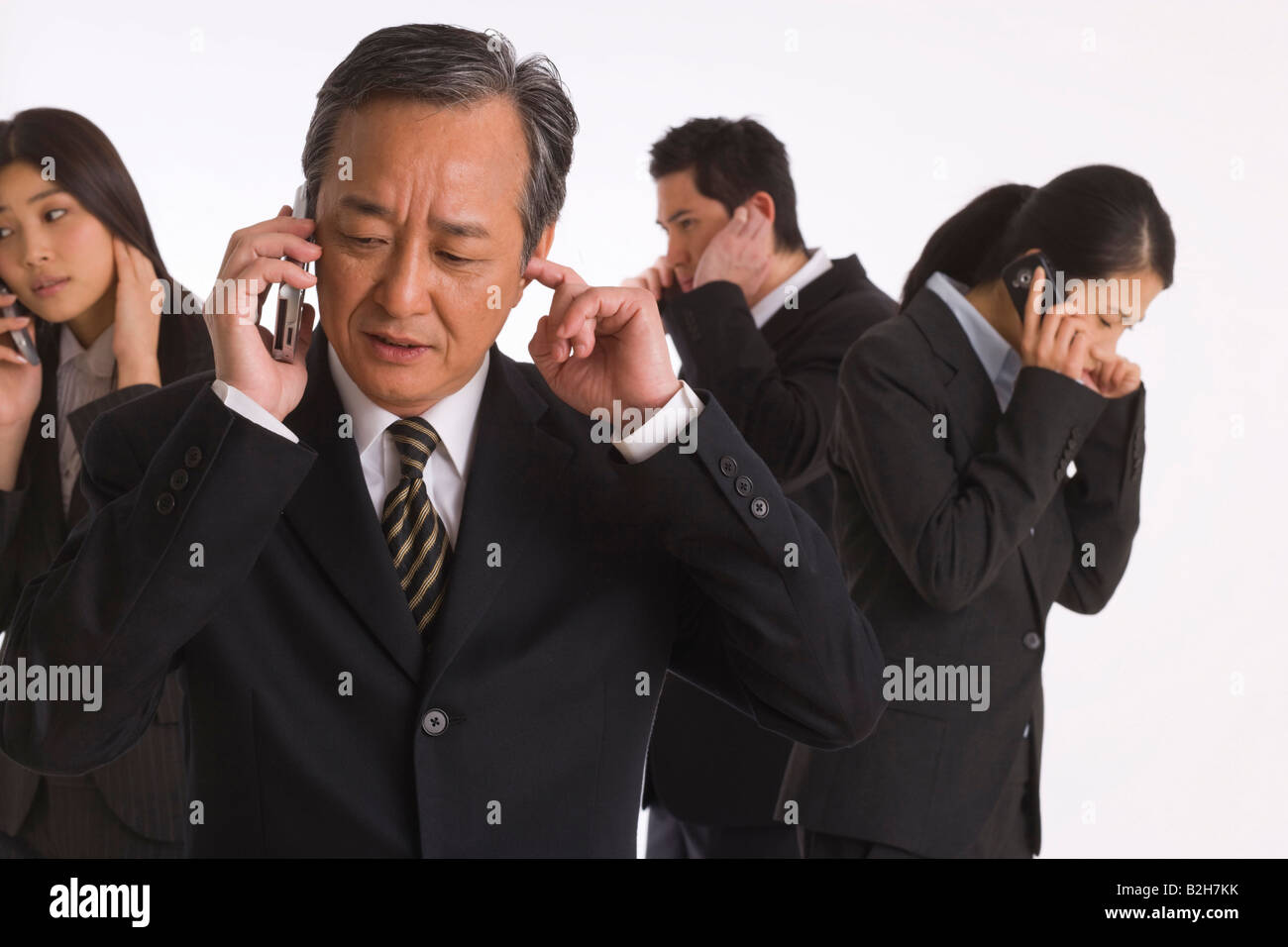 Four business executives using their mobile phones Stock Photo - Alamy