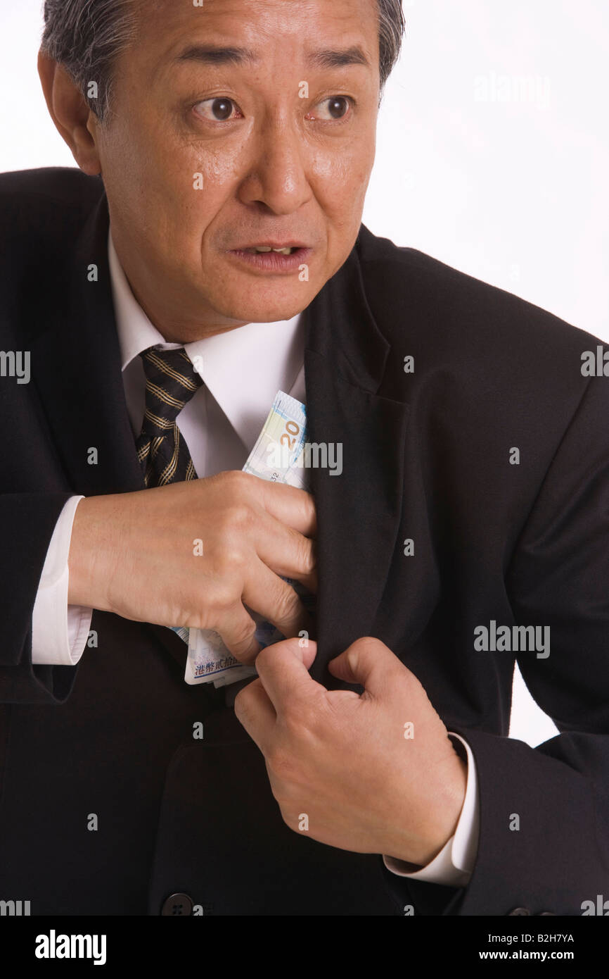 Close-up of a businessman putting money inside his coat Stock Photo - Alamy