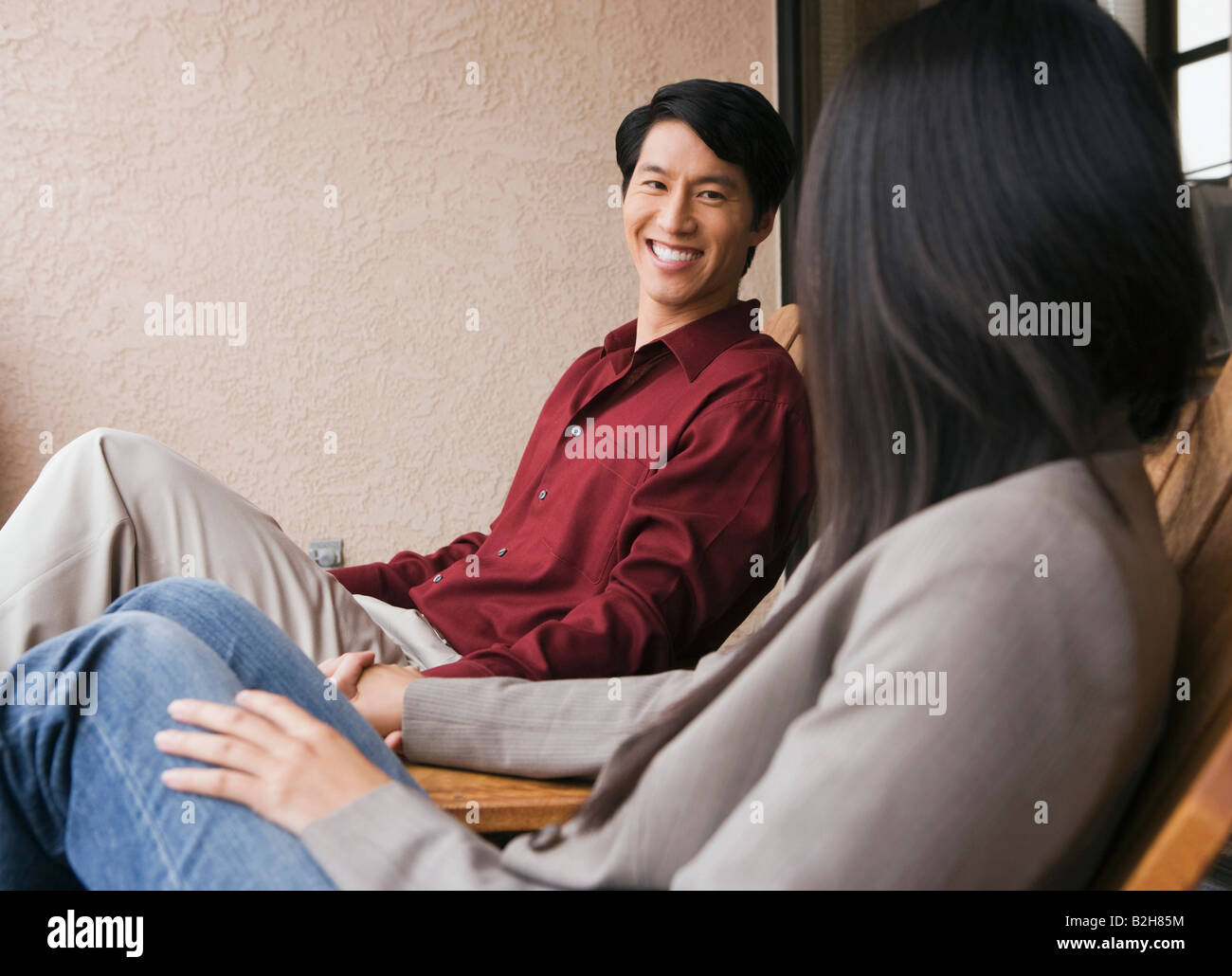 Side profile of a young couple talking with each other and smiling ...