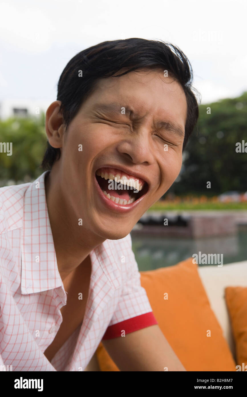 Close-up of a young man laughing, Singapore Stock Photo - Alamy