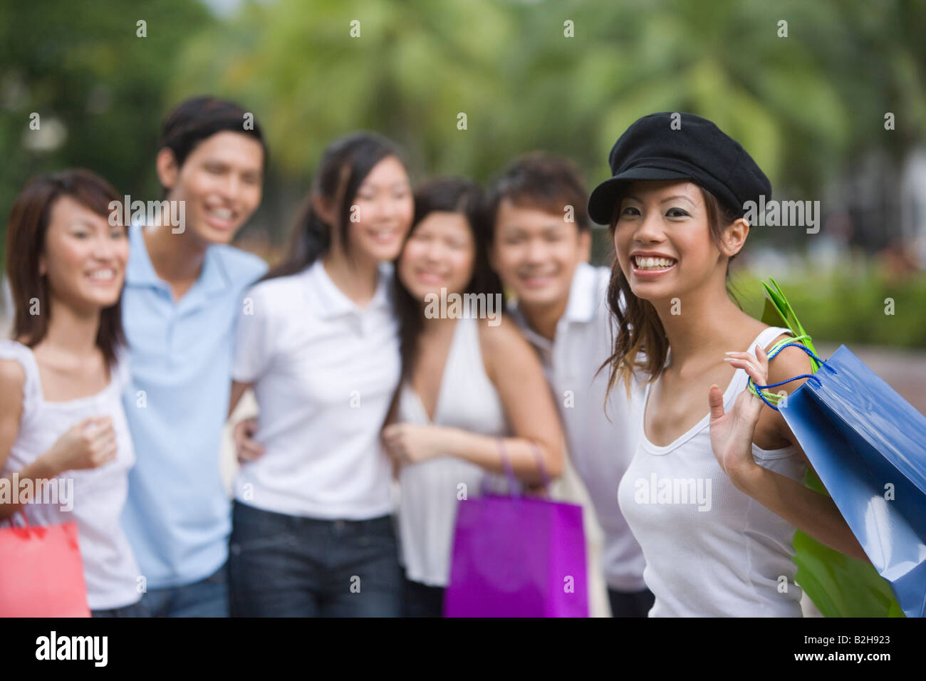 Portrait of a young woman smiling with her friends standing in the ...