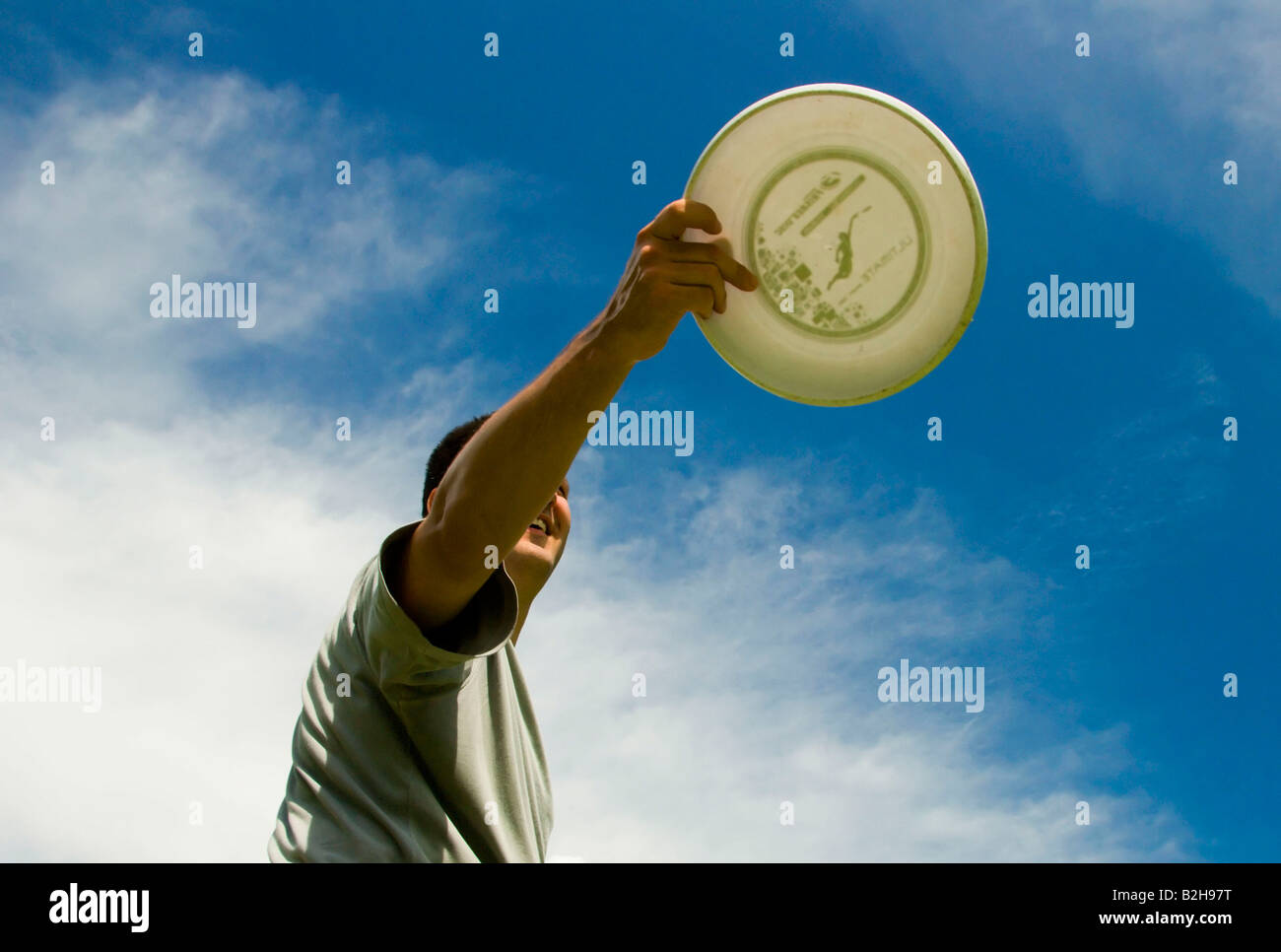 Adult male playing frisbee blue sky Stock Photo - Alamy