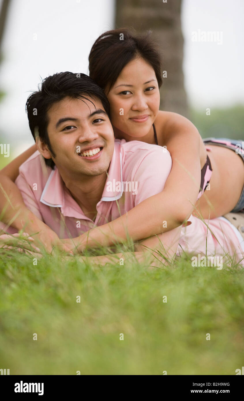 Portrait of a young woman lying on a young man Stock Photo - Alamy