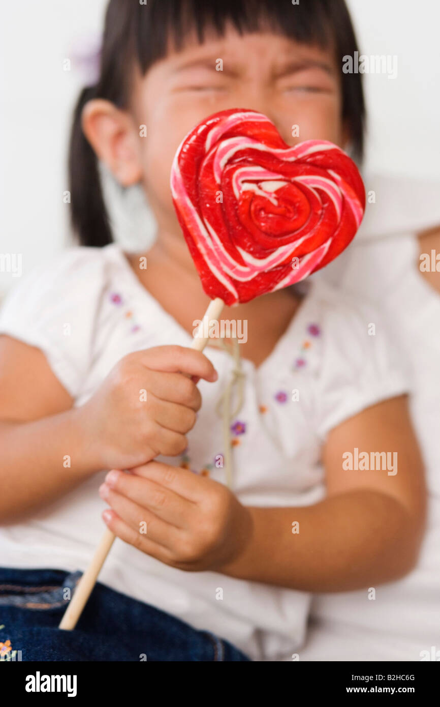 Close-up of a girl holding a lollipop and crying, Singapore Stock Photo ...